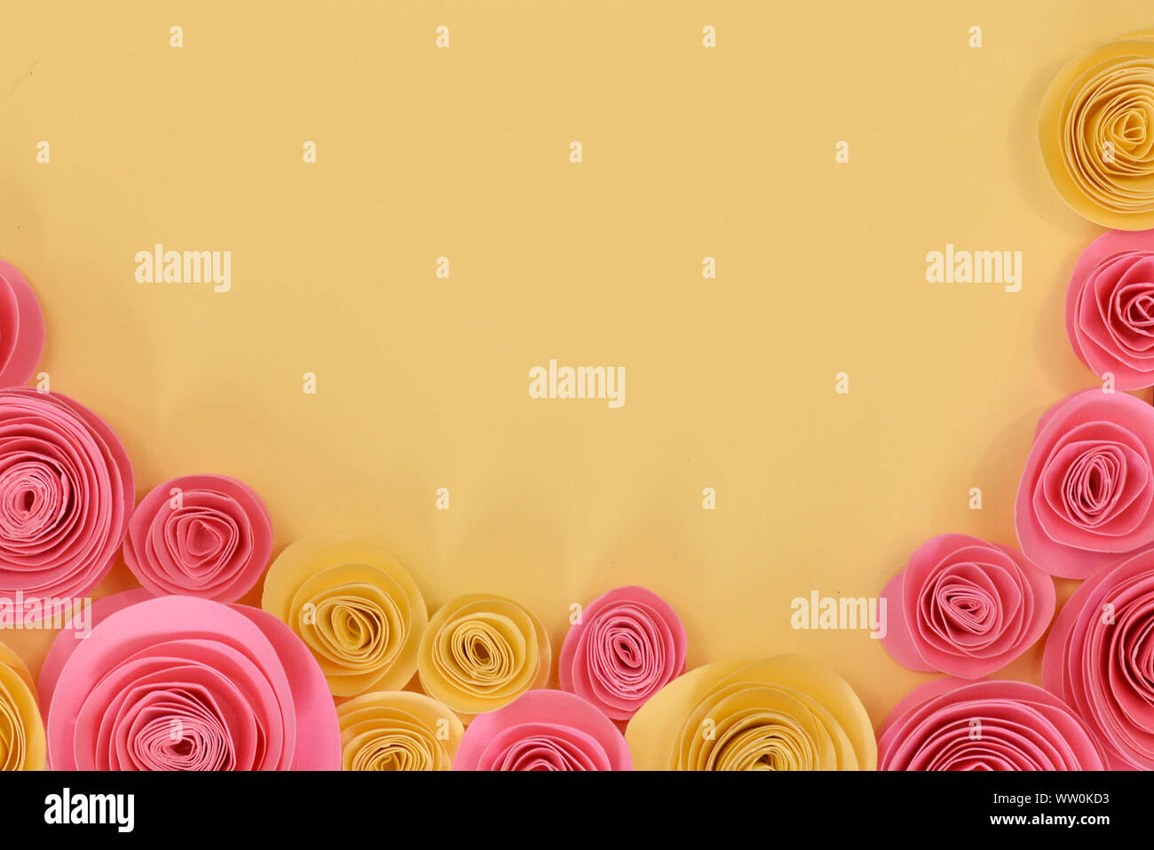 Pink and yellow rose flat lay background with crafted paper flowers at ...