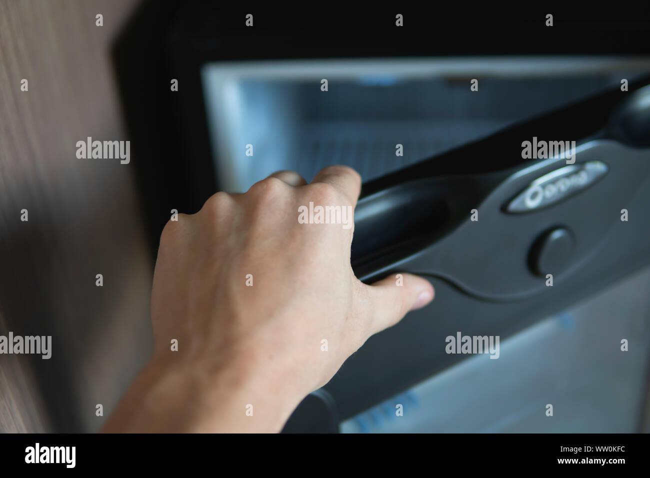 Man's hand holding a door of empty open fridge with shelves ...