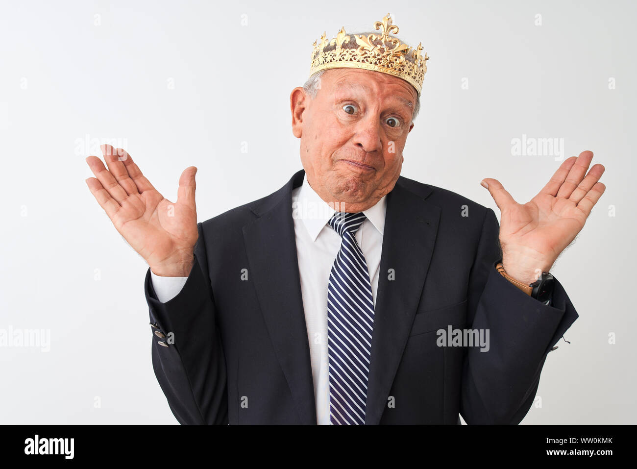 Senior grey-haired businessman wearing crown king over isolated white ...