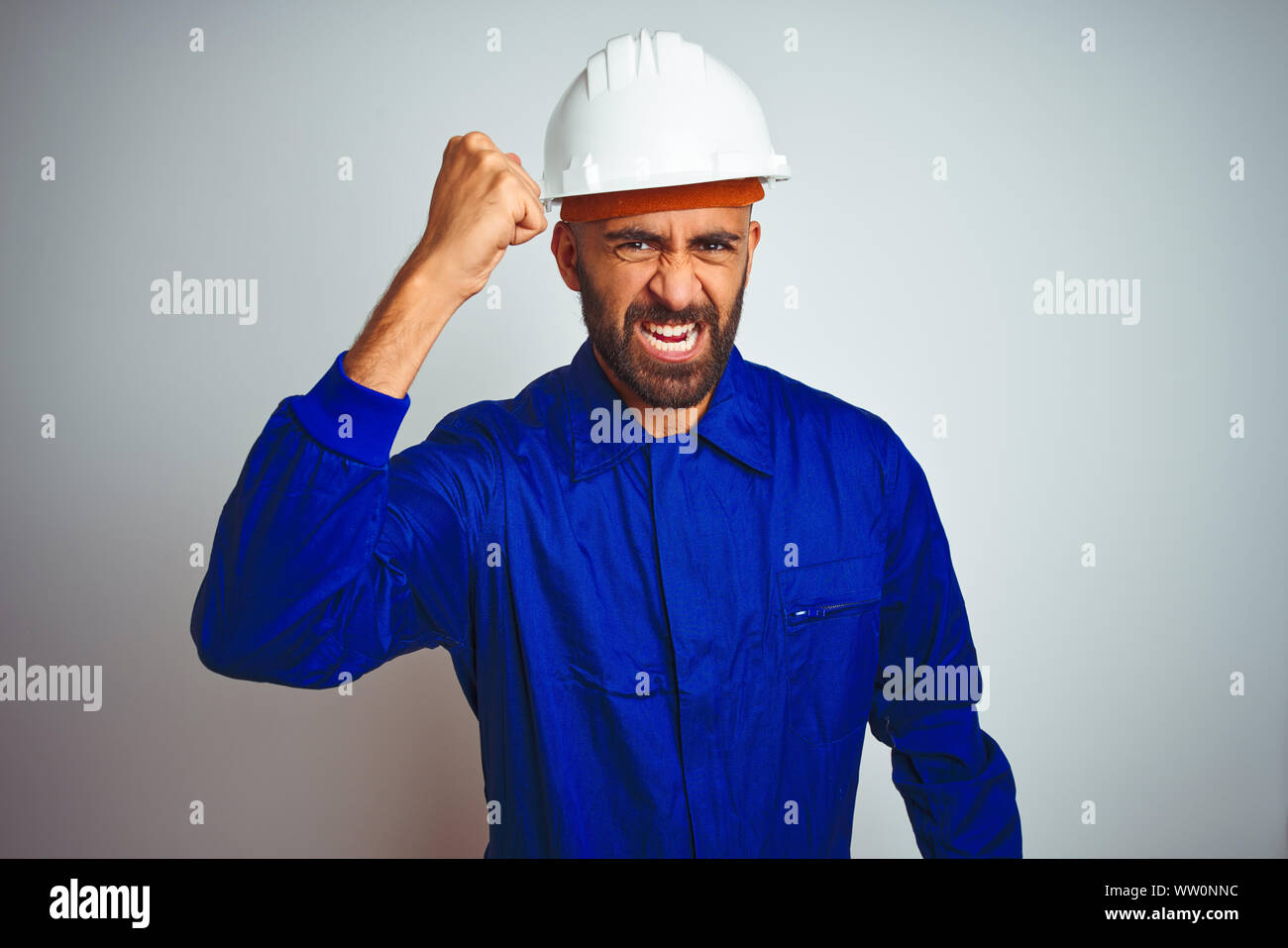 Handsome indian worker man wearing uniform and helmet over isolated ...