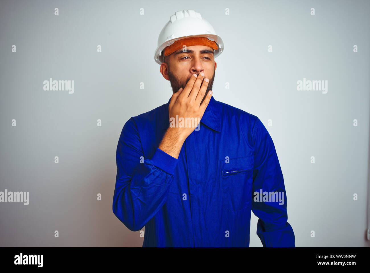 Handsome indian worker man wearing uniform and helmet over isolated ...