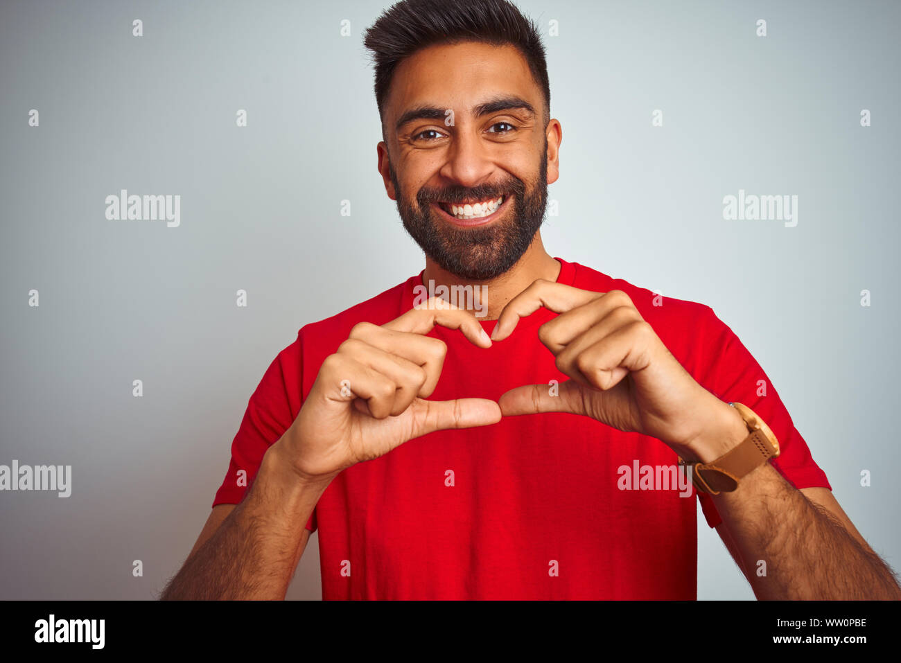 Young indian man wearing red t-shirt over isolated white background ...
