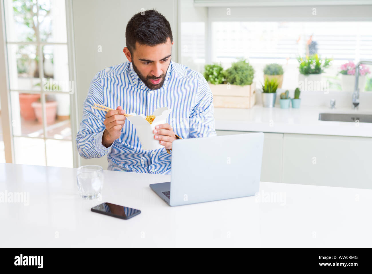 Business man eating asian food from delivery while working using ...