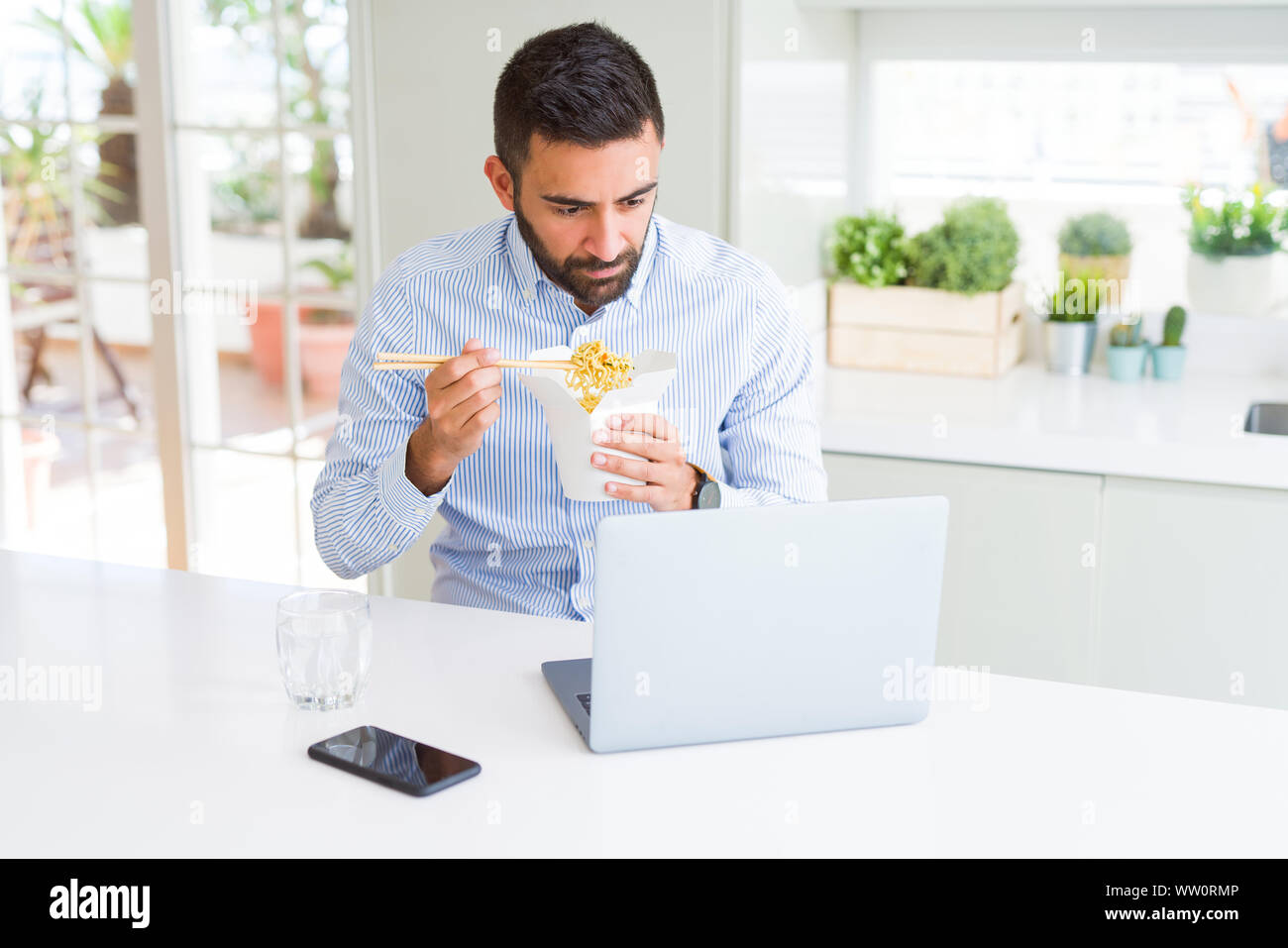 Business man eating asian food from delivery while working using ...