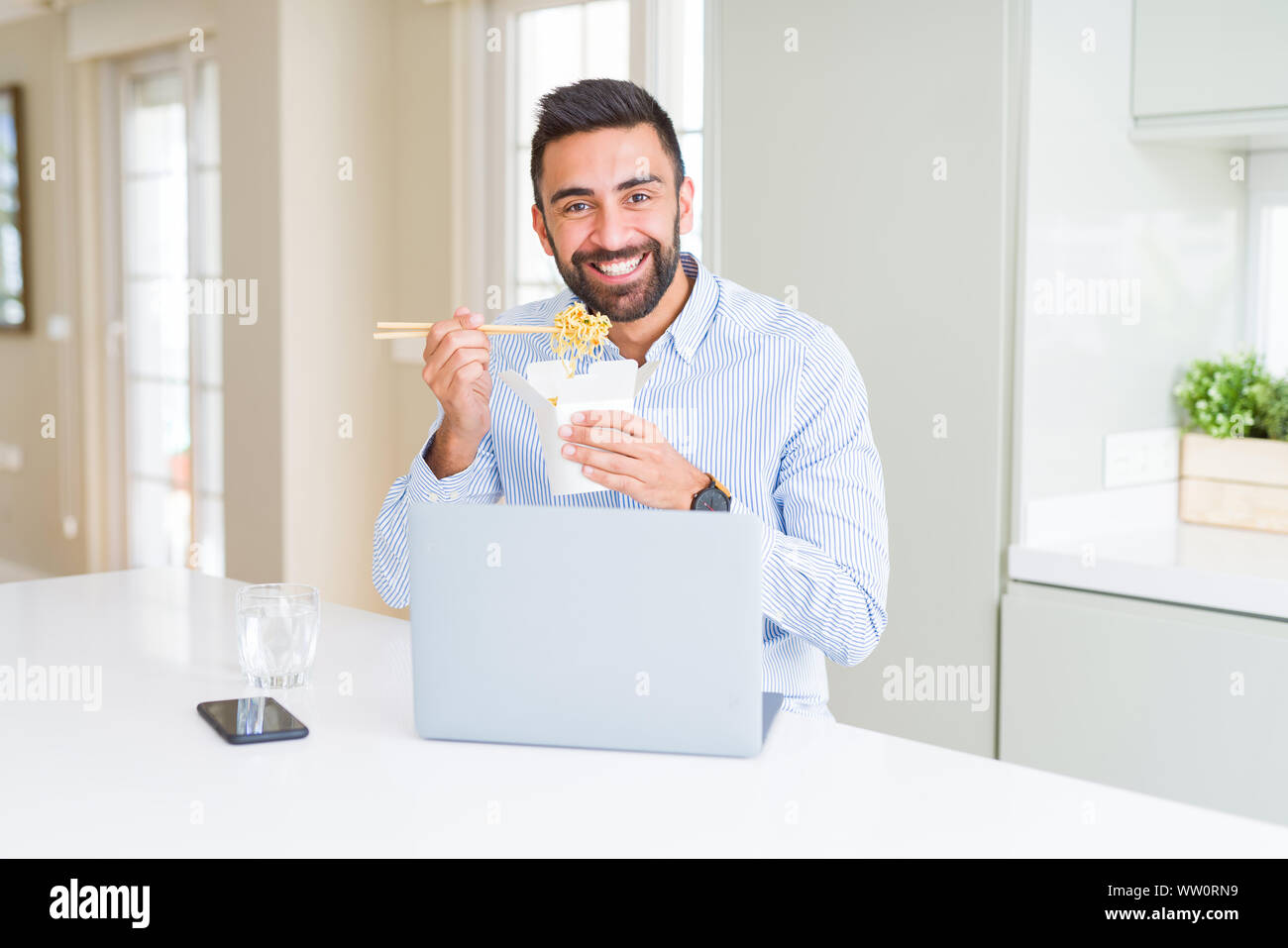 Business man eating asian food from delivery while working using ...