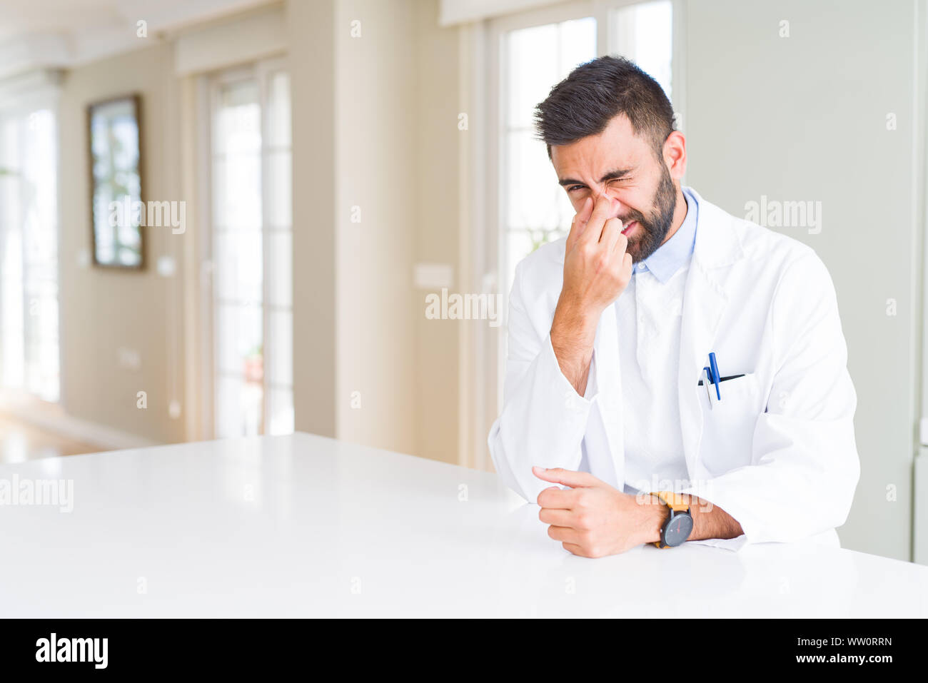 Handsome hispanic doctor or therapist man wearing medical coat at the ...