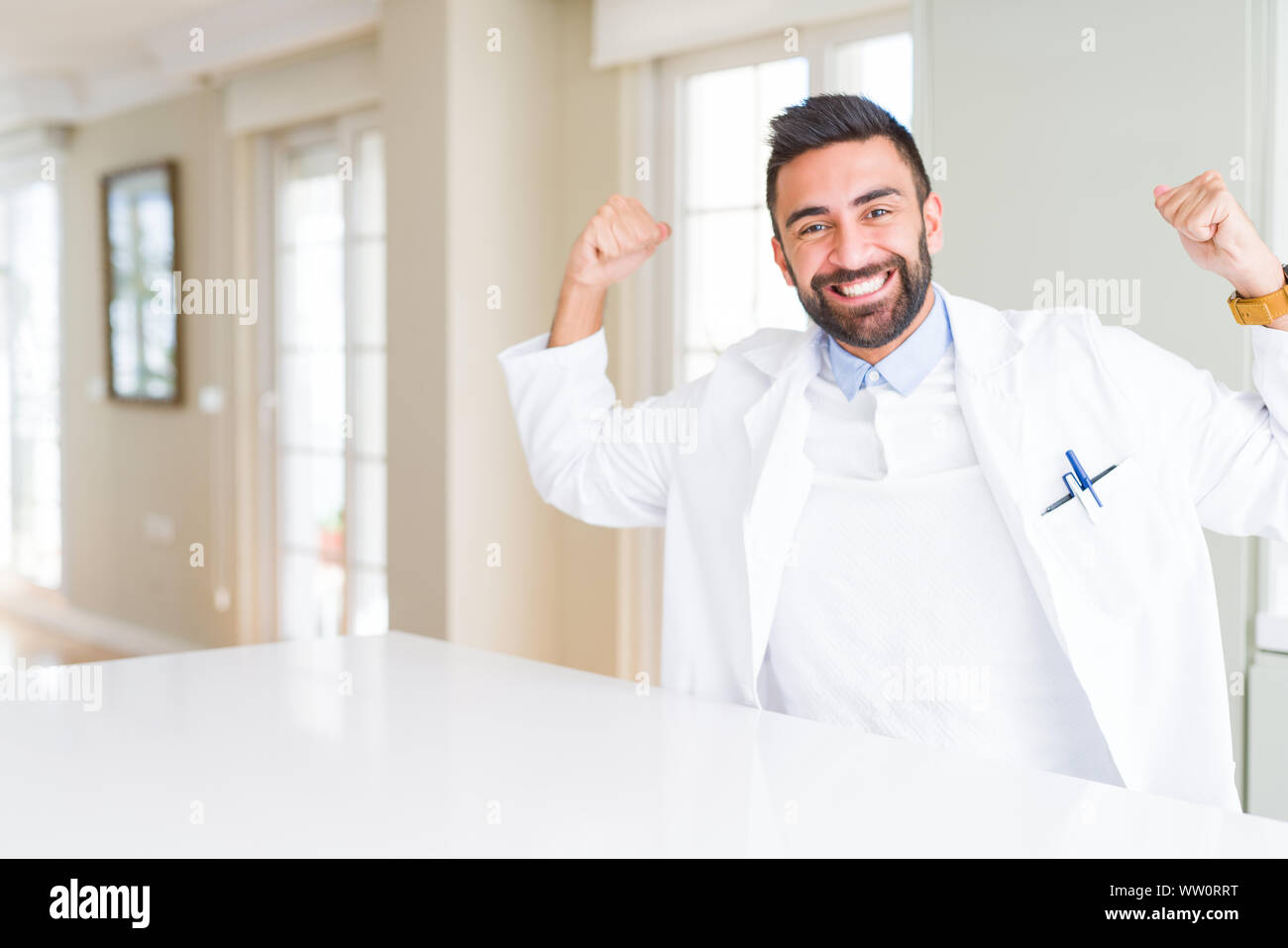 Handsome hispanic doctor or therapist man wearing medical coat at the ...