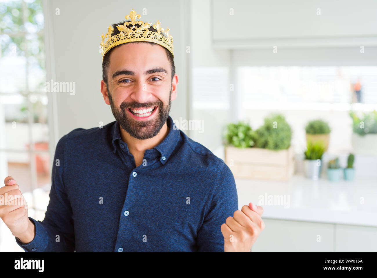 Handsome hispanic man wearing golden crown over head as the king ...