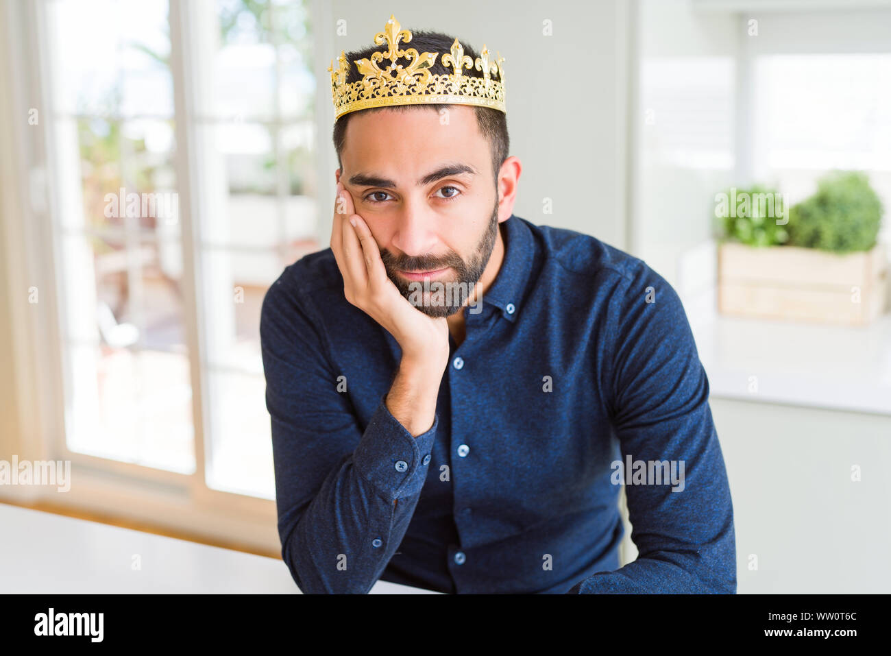 Handsome hispanic man wearing golden crown over head as the king ...
