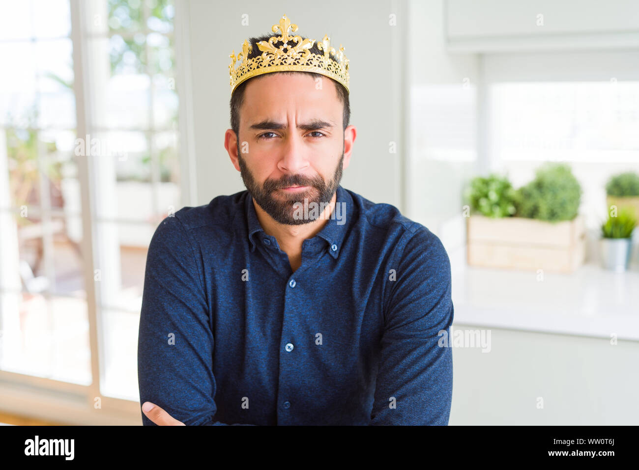Handsome hispanic man wearing golden crown over head as the king ...