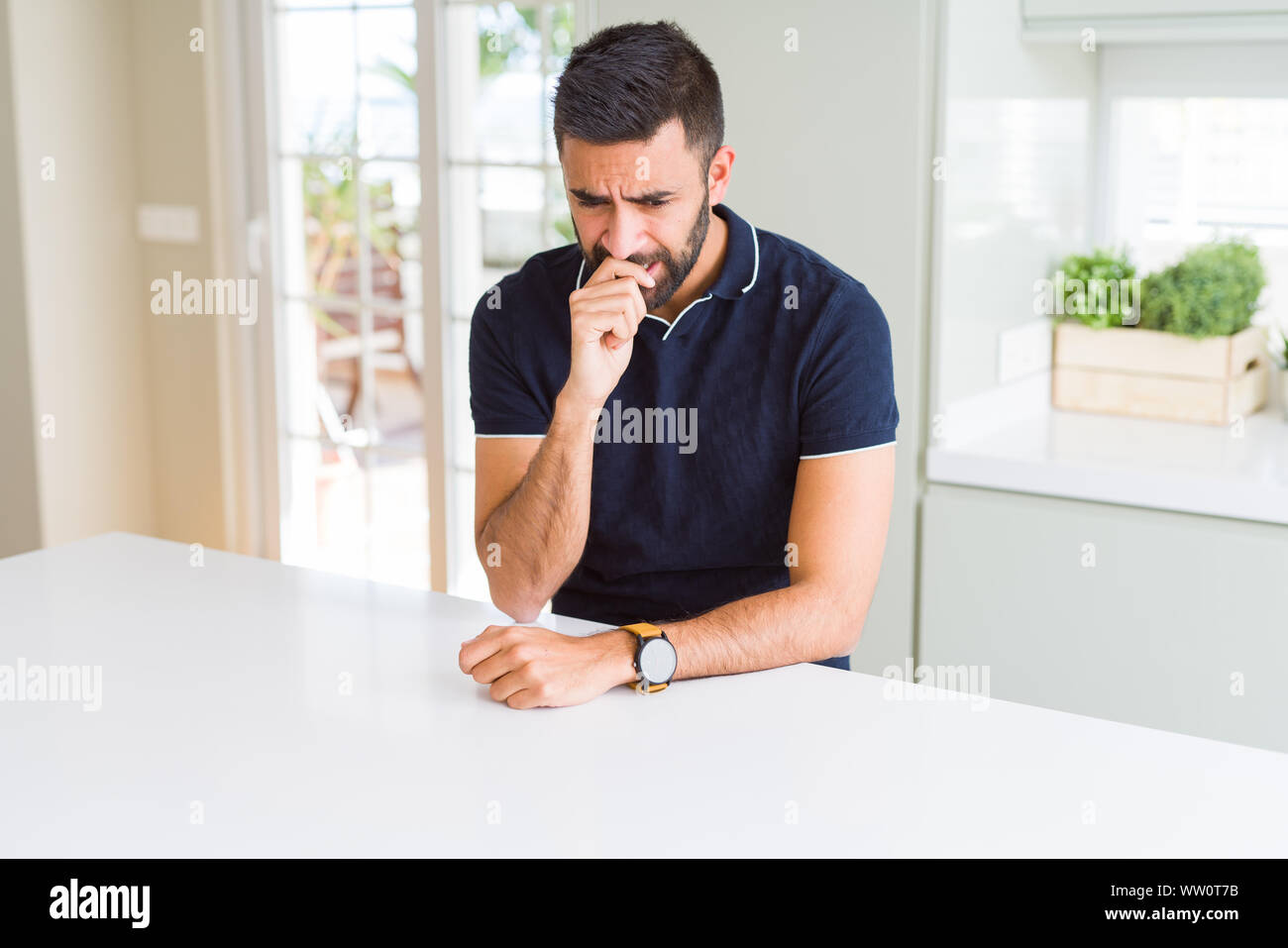 Handsome hispanic man at home looking stressed and nervous with hands ...