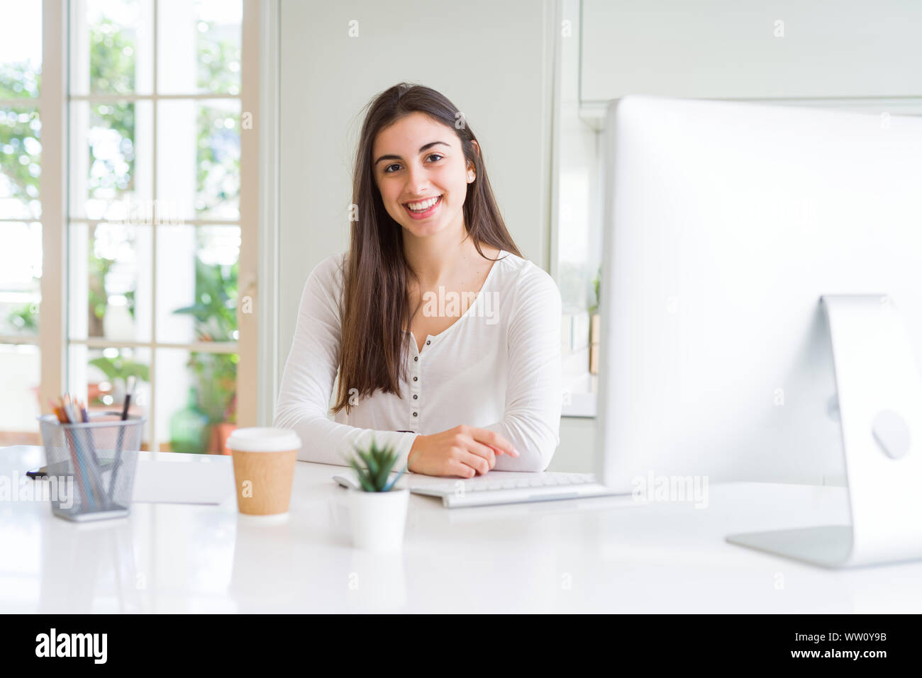 Beautiful young woman working using computer with a happy and cool ...