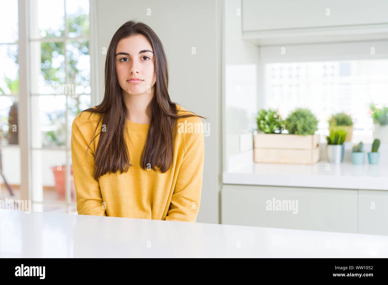 Beautiful young woman wearing yellow sweater depressed and worry for ...