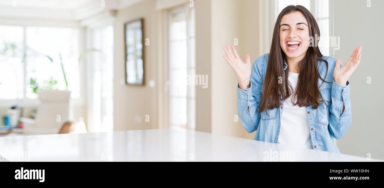 Wide angle picture of beautiful young woman sitting on white table at ...