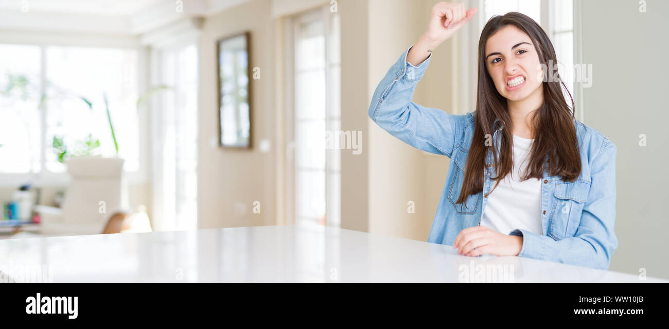 Wide angle picture of beautiful young woman sitting on white table at ...