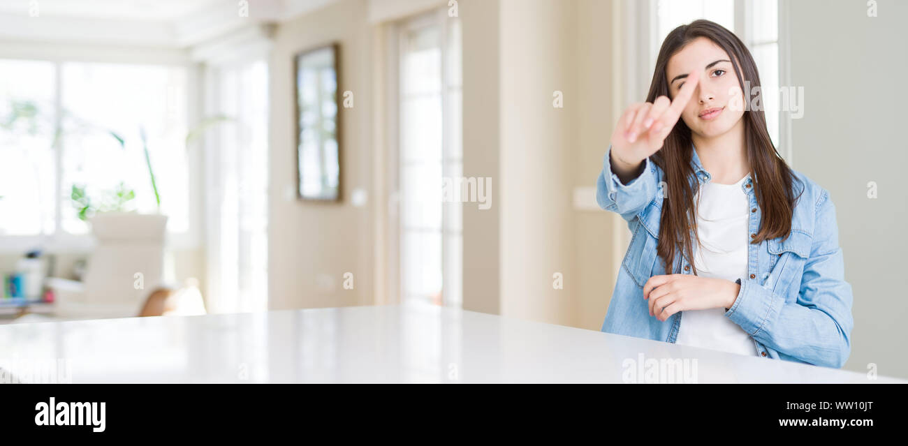 Wide angle picture of beautiful young woman sitting on white table at ...