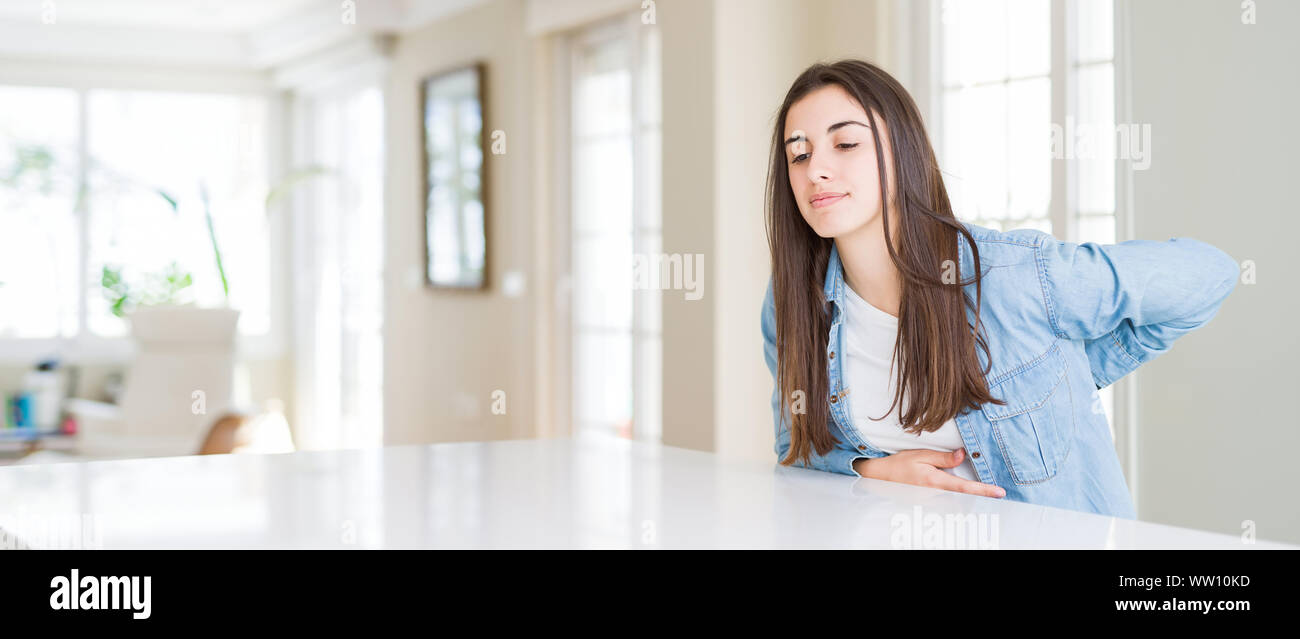 Wide angle picture of beautiful young woman sitting on white table at ...