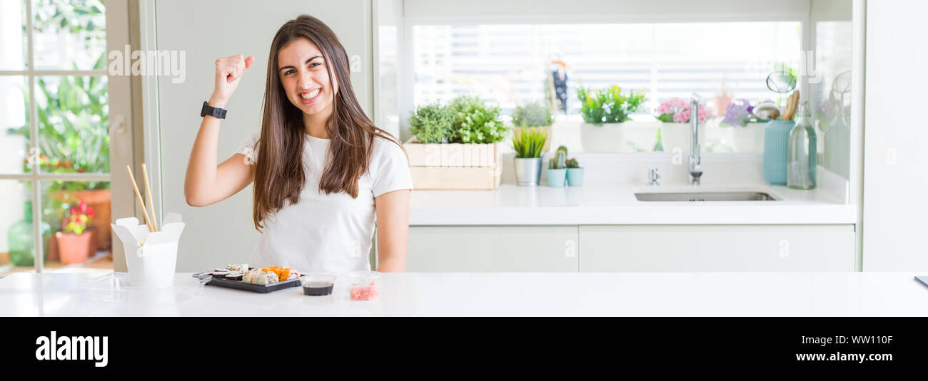 Wide angle picture of beautiful young woman eating asian sushi from ...