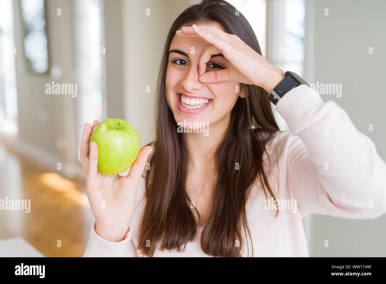 Beautiful young woman eating healthy green apple fruit with happy face ...