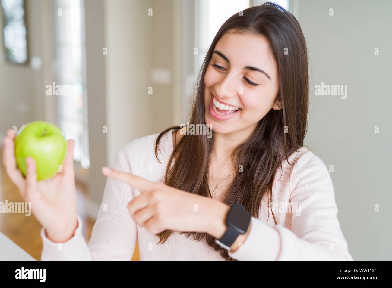 Beautiful young woman eating healthy green apple fruit very happy ...