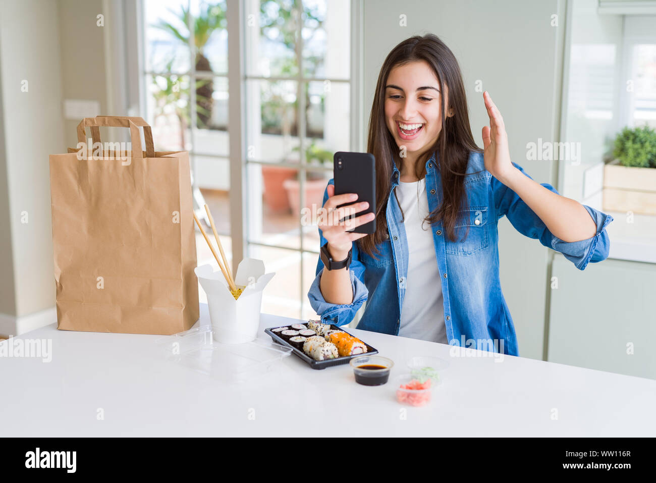 Beautiful young woman ordering food delivery from app using smartphone ...