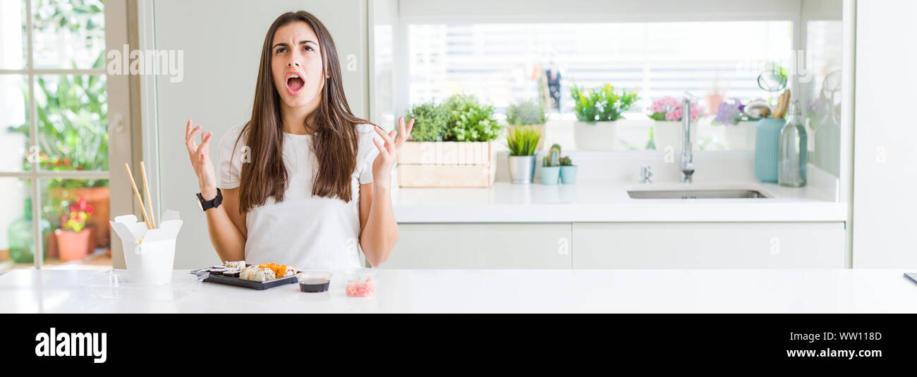 Wide angle picture of beautiful young woman eating asian sushi from ...