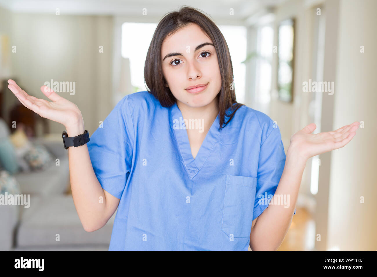 Beautiful young nurse woman at the clinic clueless and confused ...