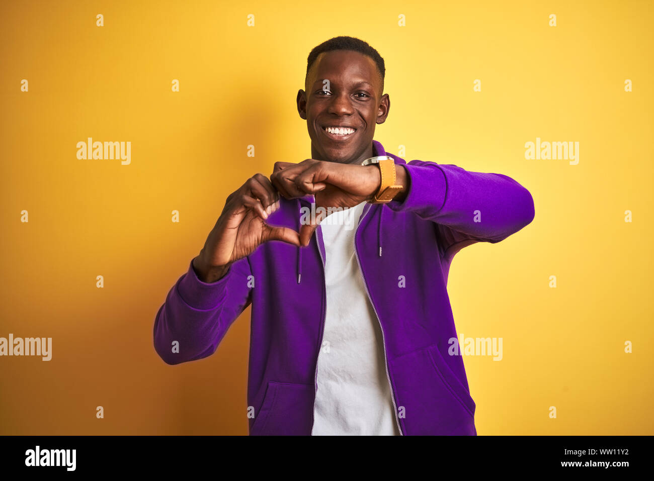 African american man wearing purple sweatshirt standing over isolated ...