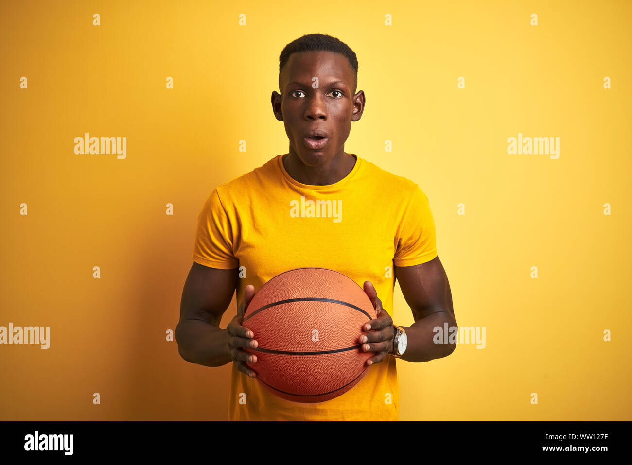 African american athlete man holding basketball ball standing over ...