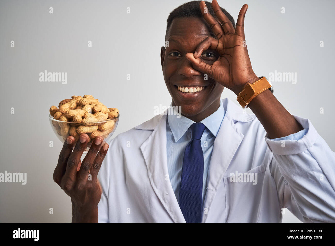 African american doctor man holding bowl with peanuts over isolated ...