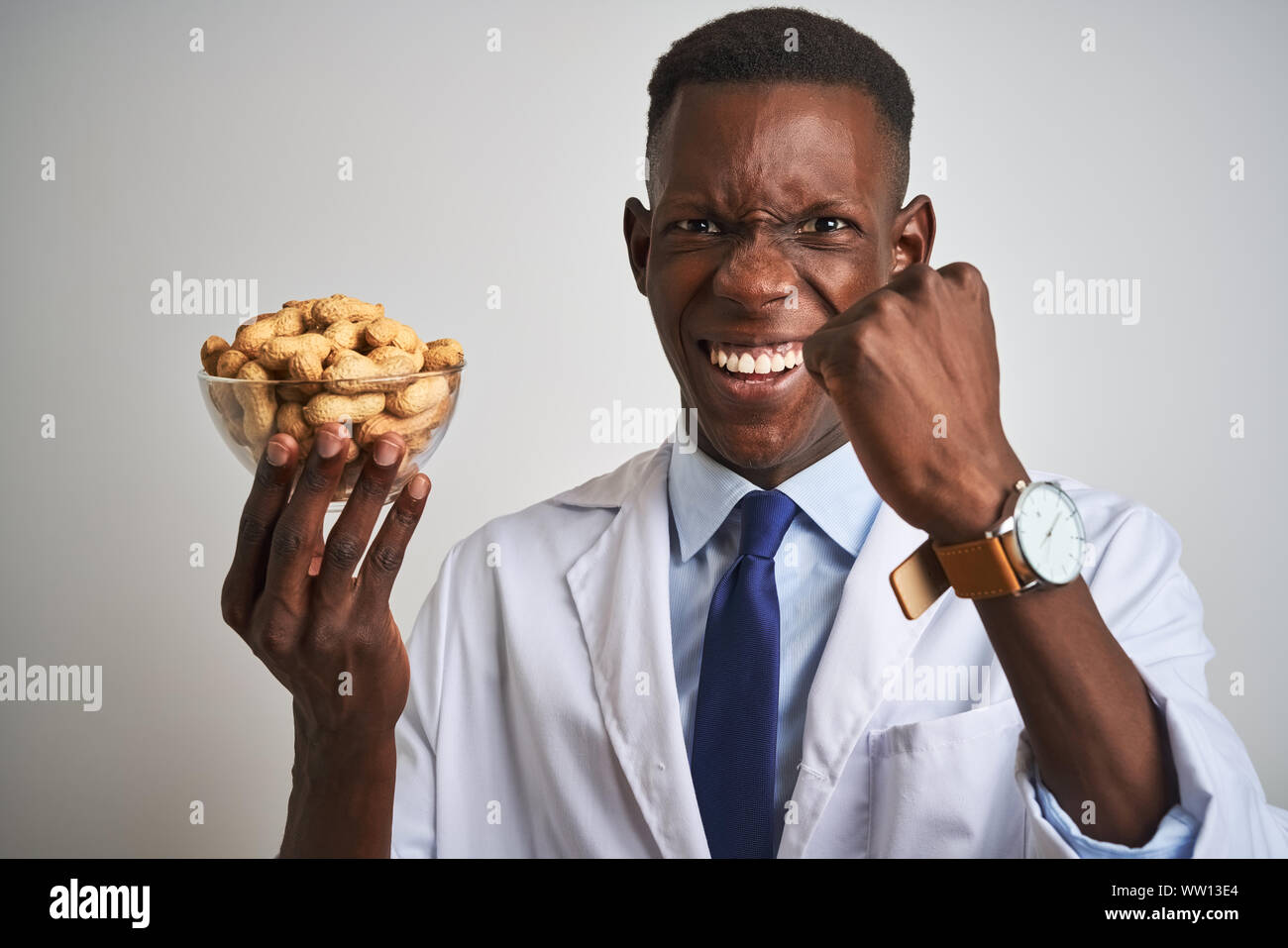 African american doctor man holding bowl with peanuts over isolated ...