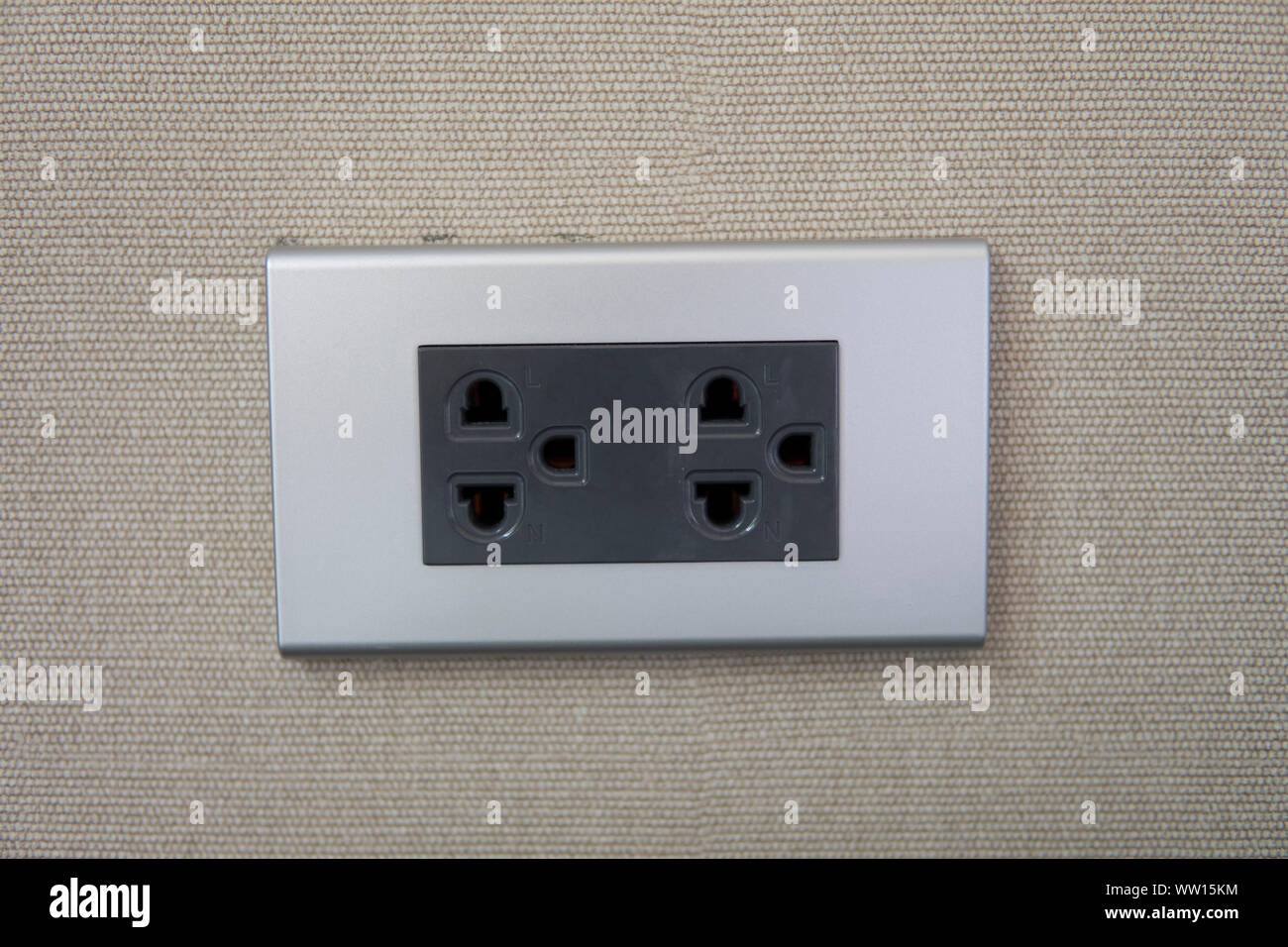 Grey universal electricity sockets plug on a yellow wall Stock Photo ...