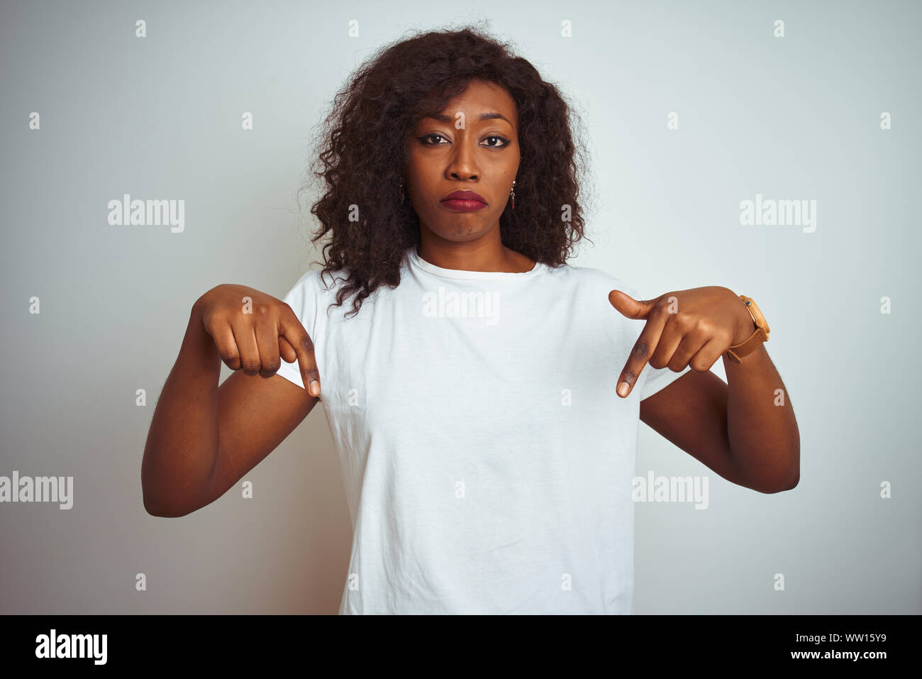 Young african american woman wearing t-shirt standing over isolated white background Pointing ...