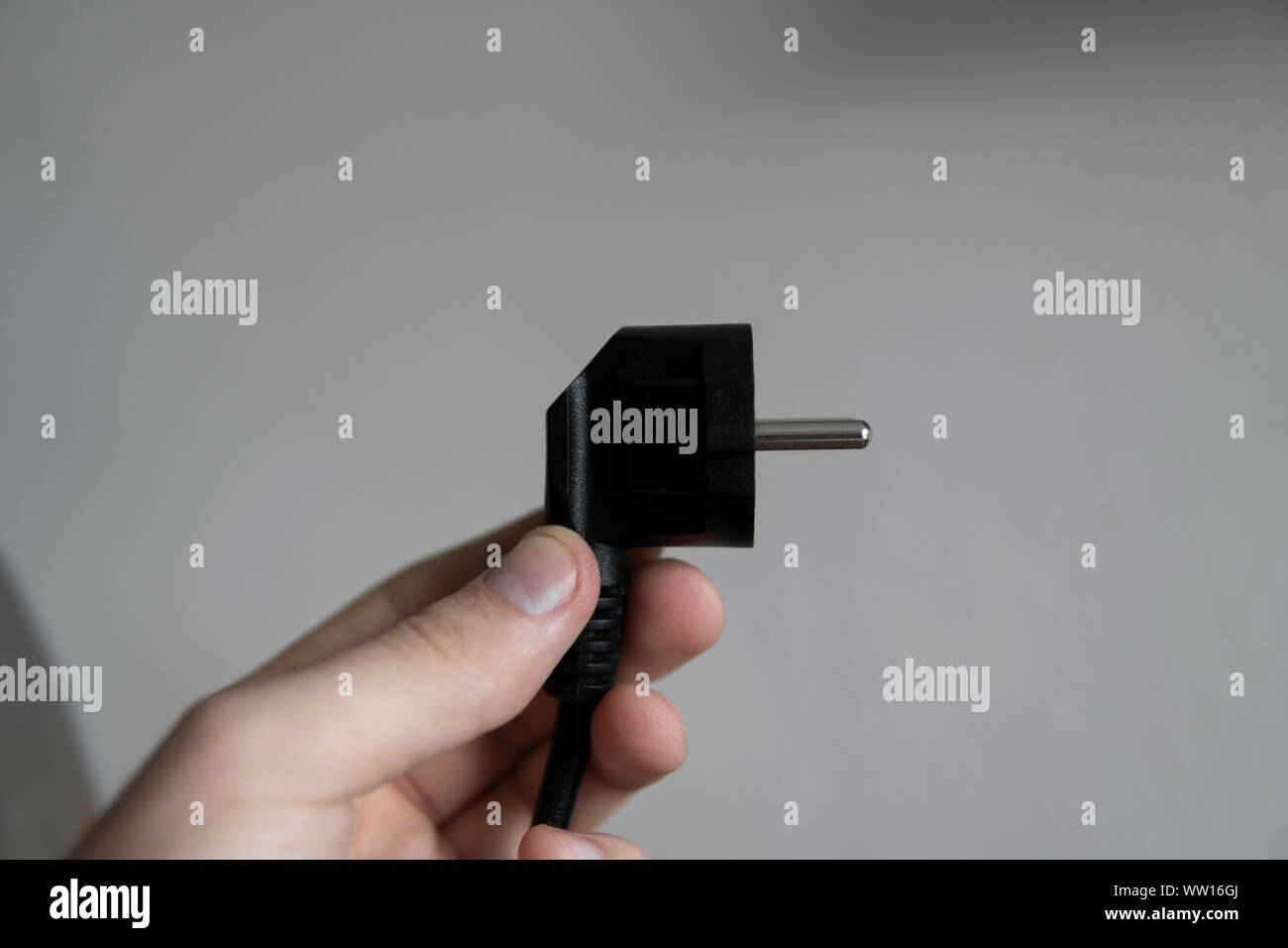 Hand holding black electrical plug hi-res stock photography and images ...