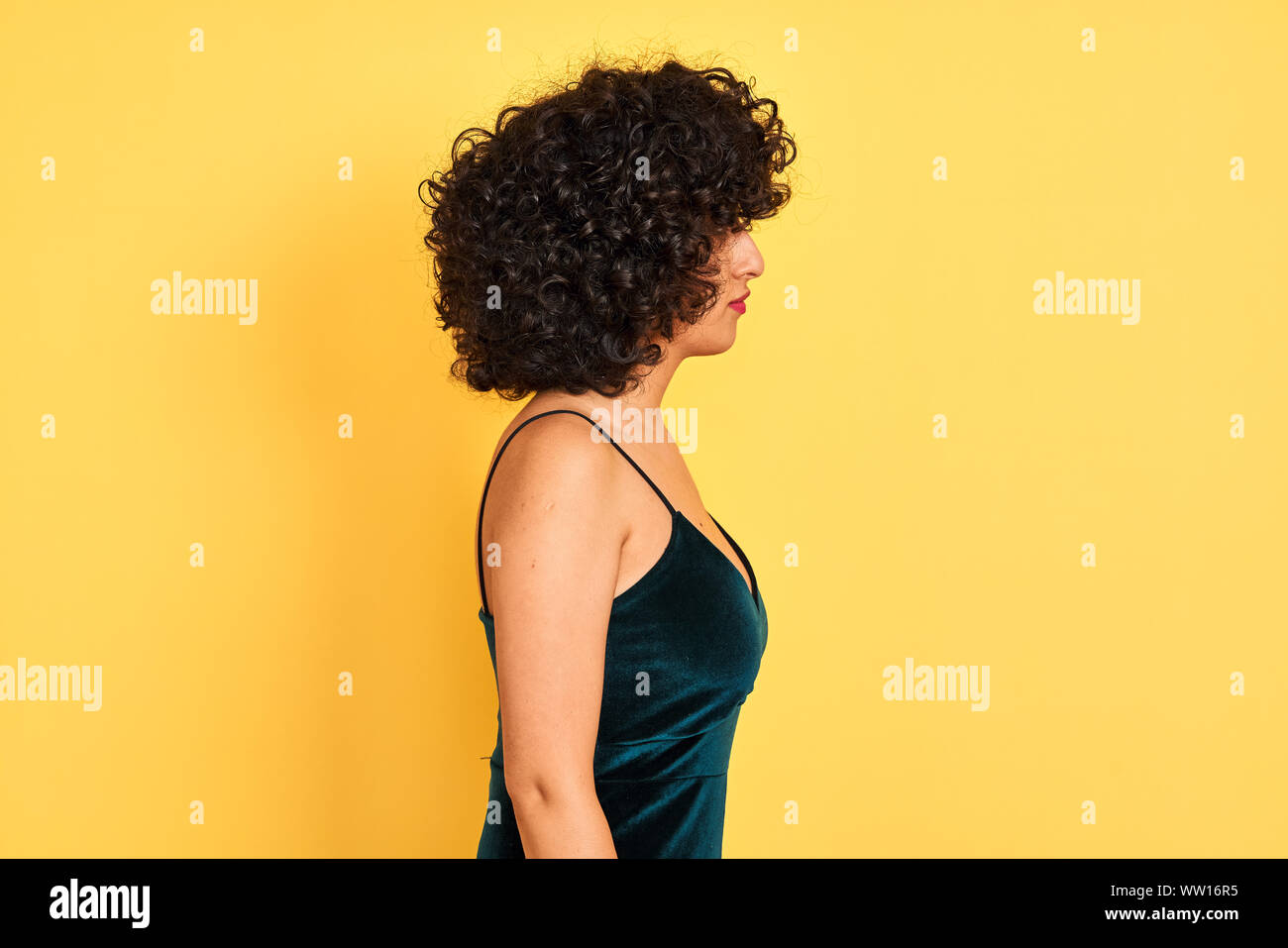 Young arab woman with curly hair wearing elegant dress over isolated ...