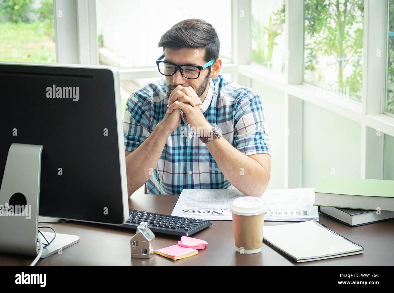 Young caucasian businessman relaxing at his work station after finished ...