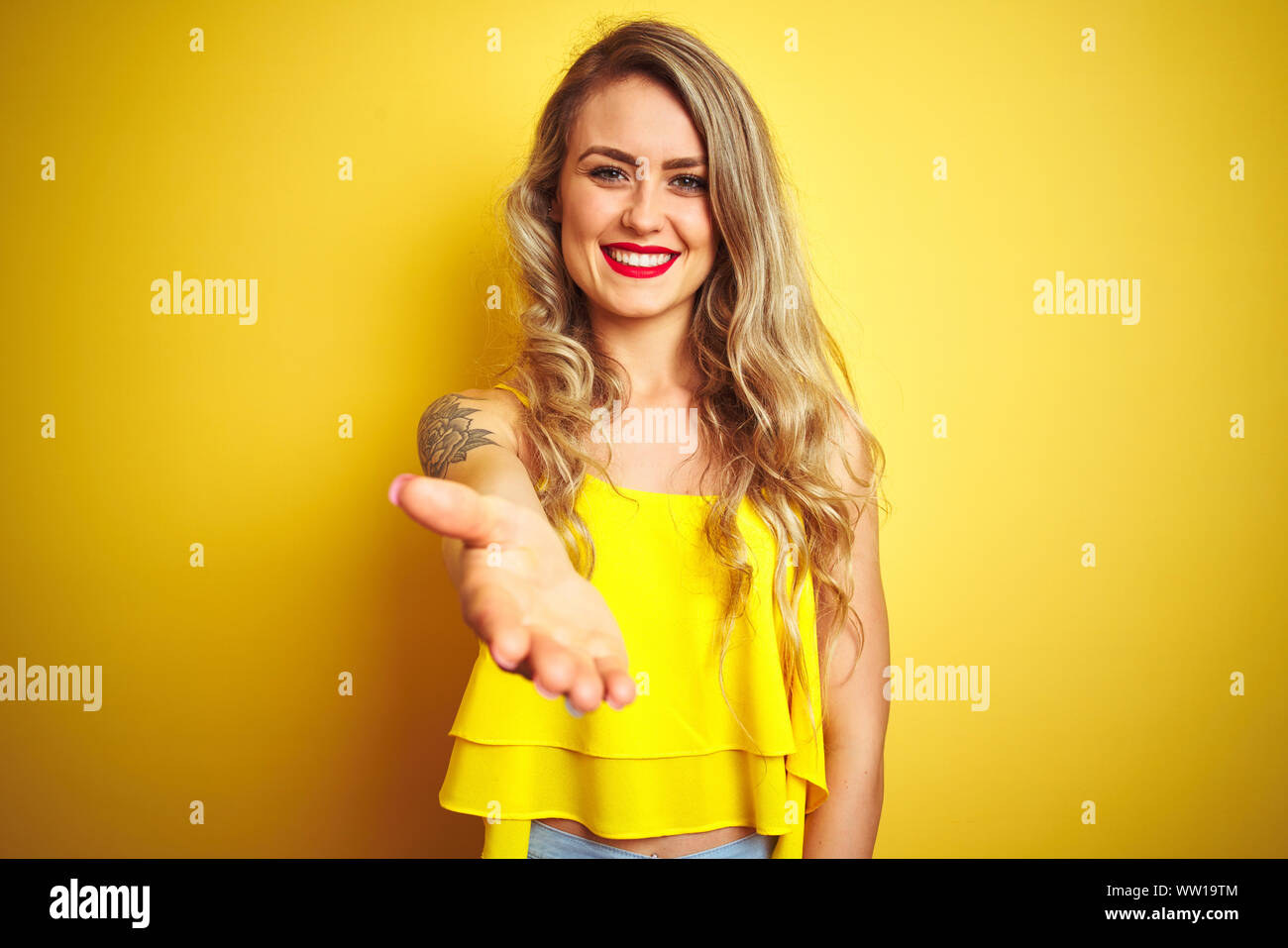 Young attactive woman wearing t-shirt standing over yellow isolated ...