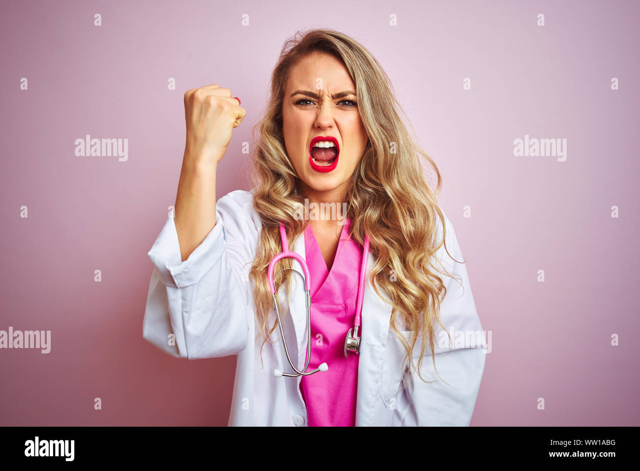 Young beautiful doctor woman using stethoscope over pink isolated ...