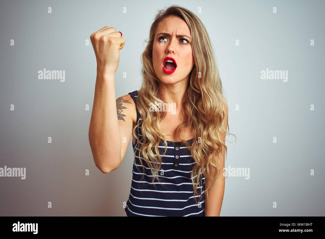 Young beautiful woman wearing stripes t-shirt standing over white ...