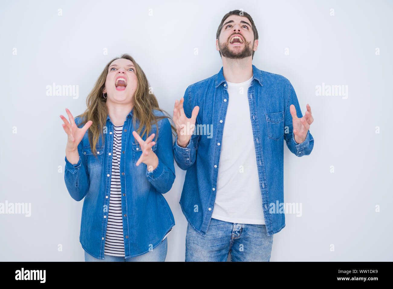 Young beautiful couple standing together over white isolated background ...