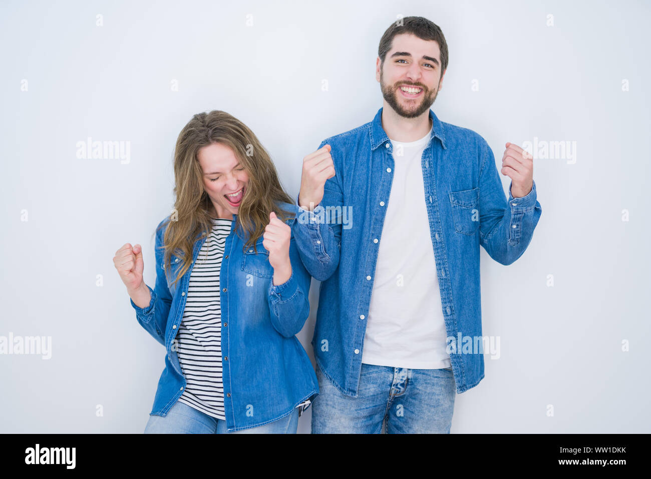 Young beautiful couple standing together over white isolated background ...
