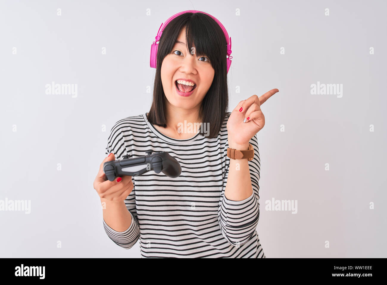 Chinese gamer woman playing video game using headphones over isolated ...