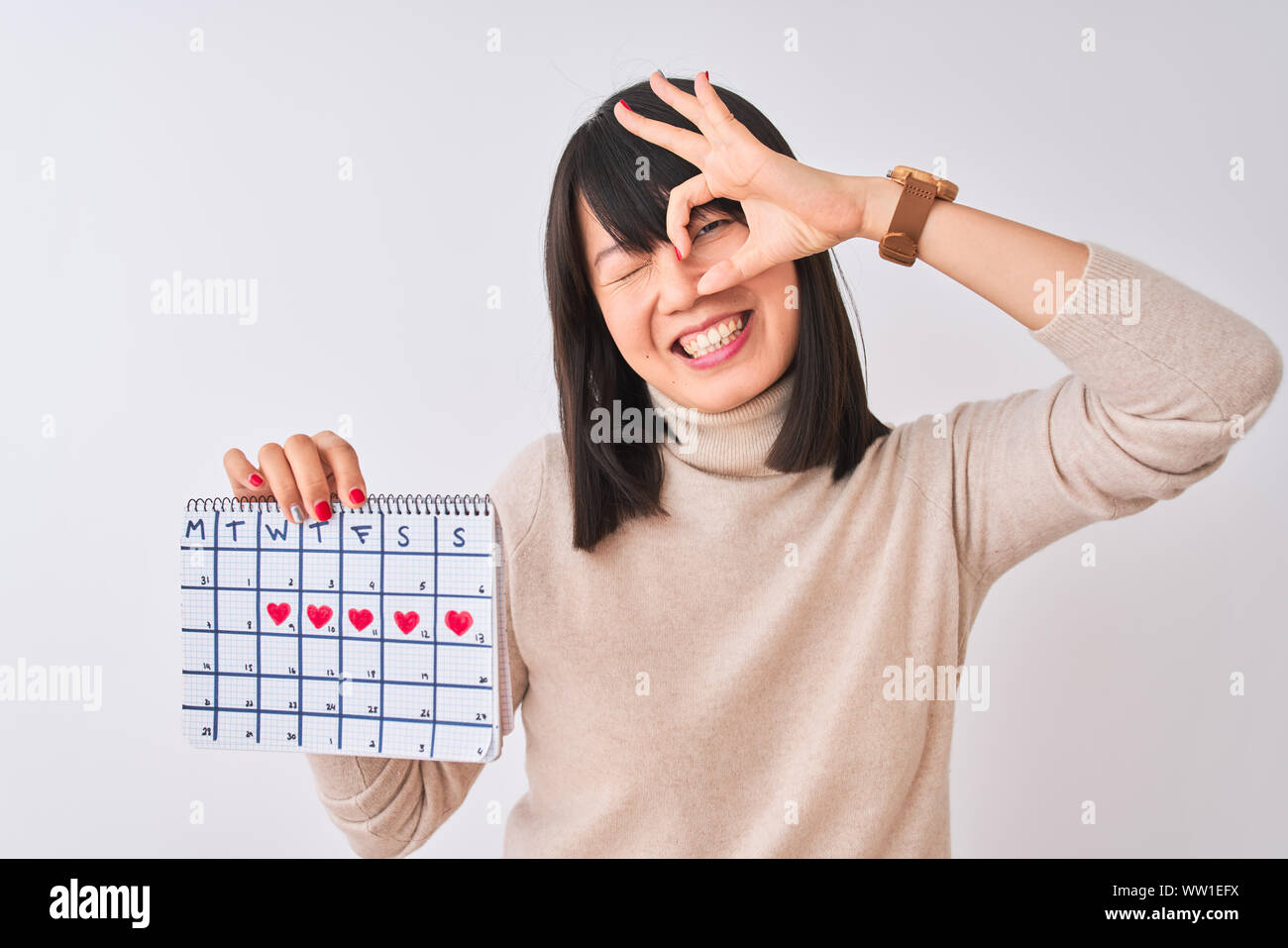 Young beautiful Chinese woman holding menstruation calendar over ...