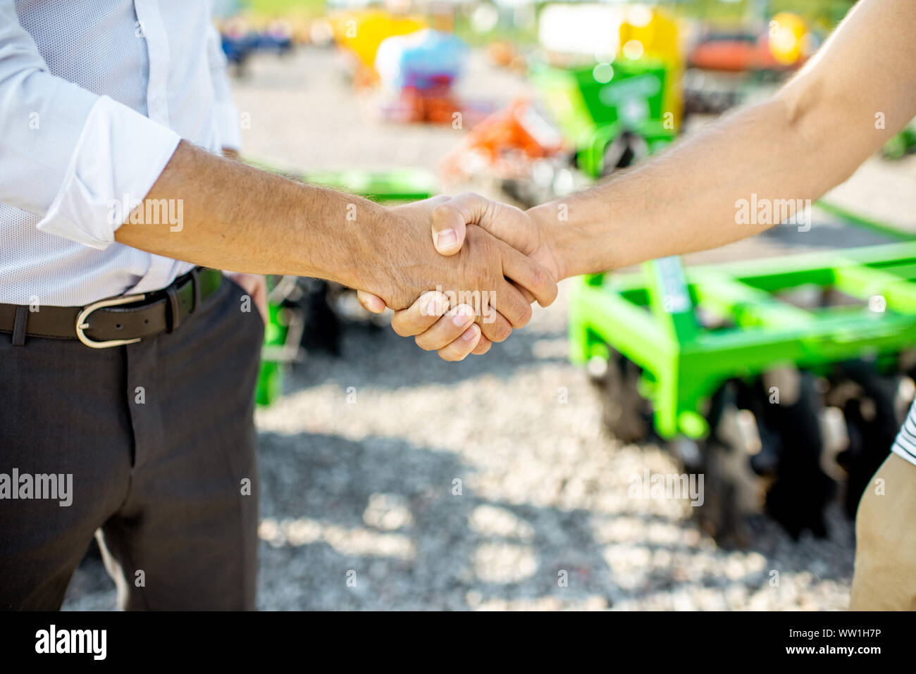 Buyer shaking hand with salesman on the open ground of the agricultural ...