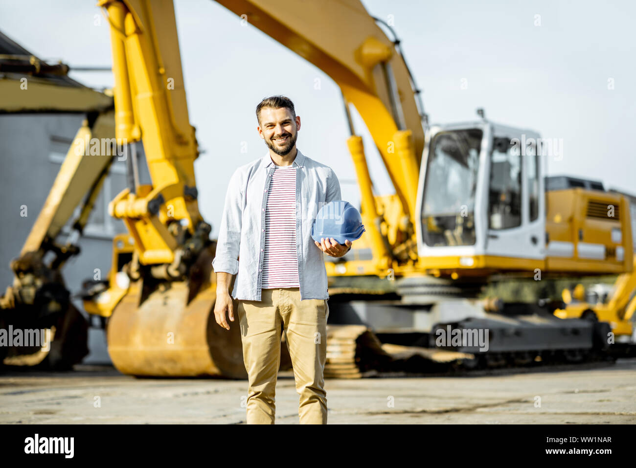 Portrait of a handsome builder standing on the open ground of the shop ...
