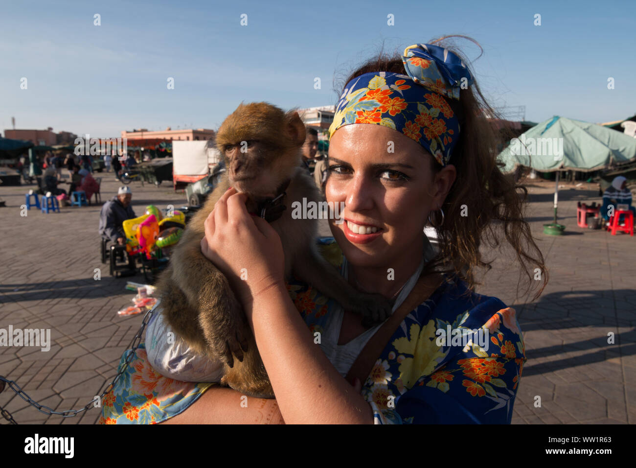 Beautiful brunette woman portrait with a headscarf and a monkey in her ...
