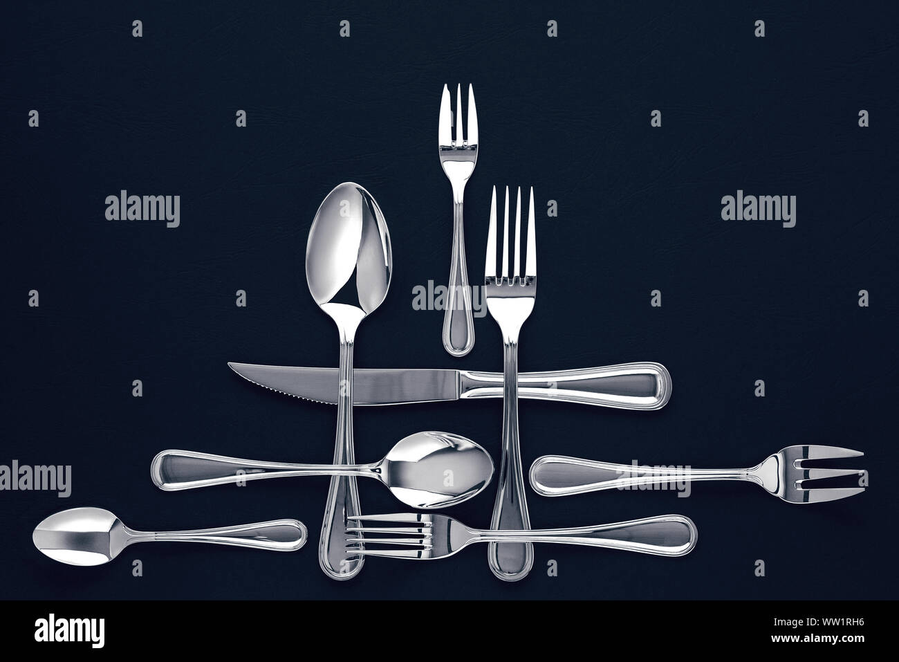 Stylish cutlery, on a dark blue background. View from above. Free space ...