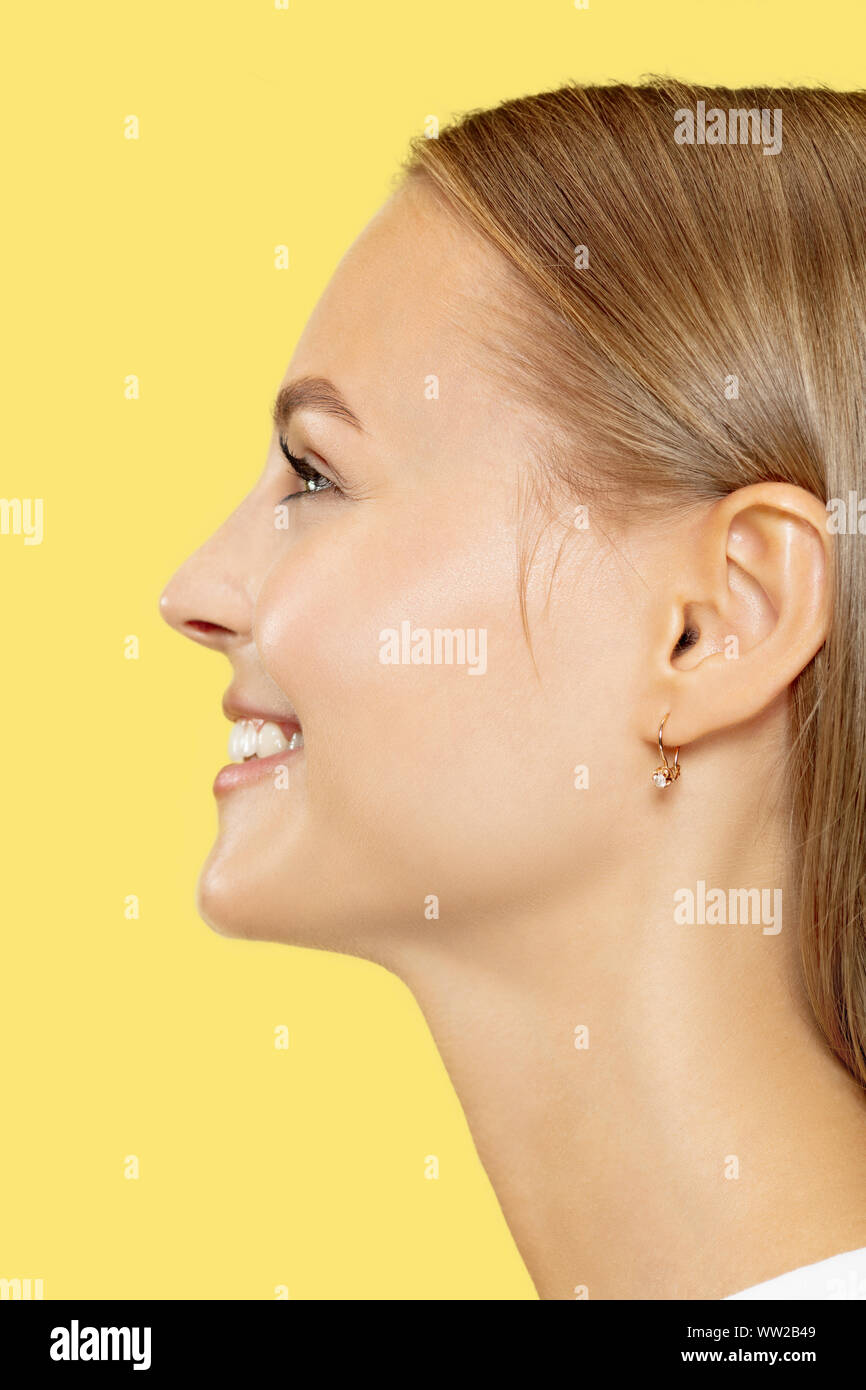Caucasian young woman's close up shot on yellow studio background ...