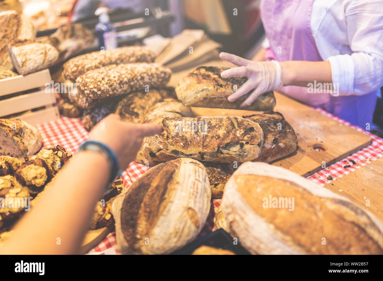 Close up oh hand picking up bread in bakery Stock Photo - Alamy