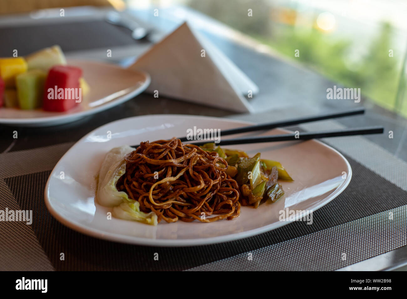 Chinese fried noodles and chopsticks. Side dish of celery and carrots ...